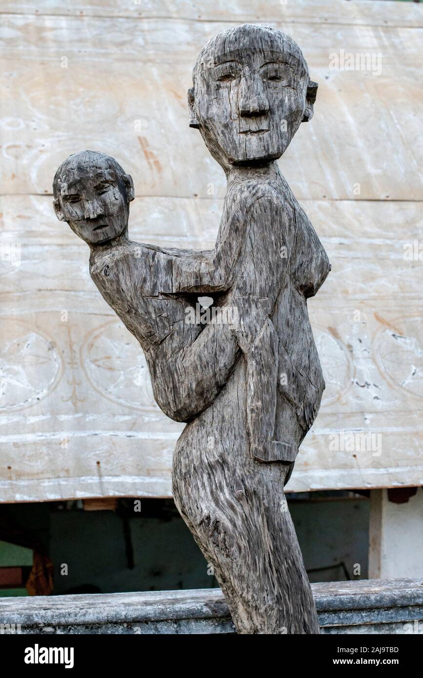 A old statue in scuplted wood representing a mother carrying his child ...