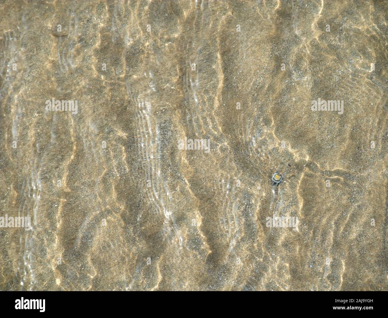 Water flowing over sand forming pattern Stock Photo - Alamy