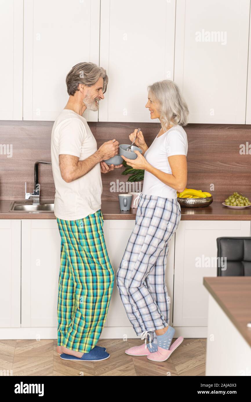 Couple in pajamas pants standing in the kitchen Stock Photo - Alamy