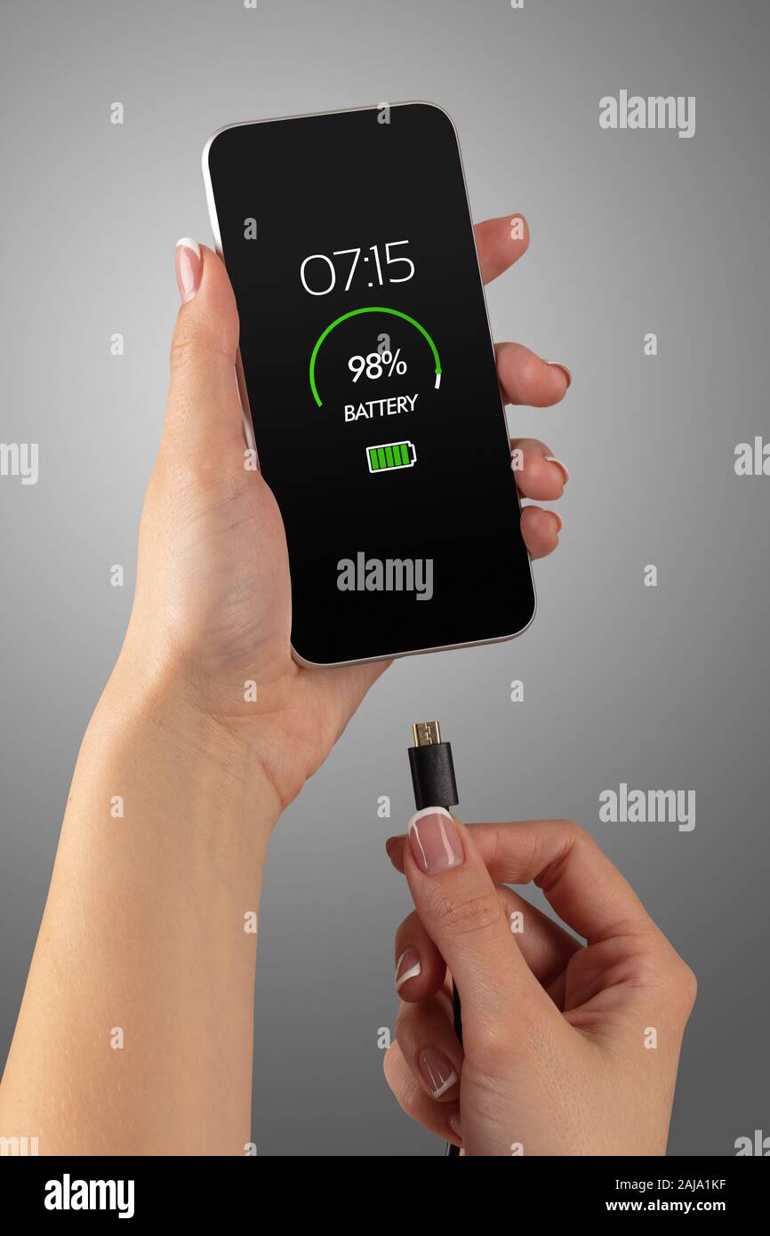 Elegant hand charging cellphone with low battery Stock Photo - Alamy
