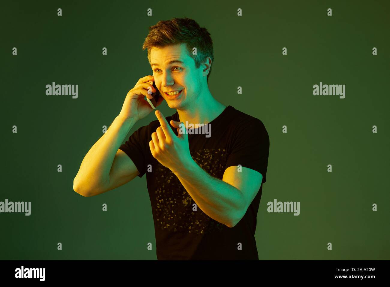 Talking on phone, smiling. Caucasian man's portrait isolated on green ...