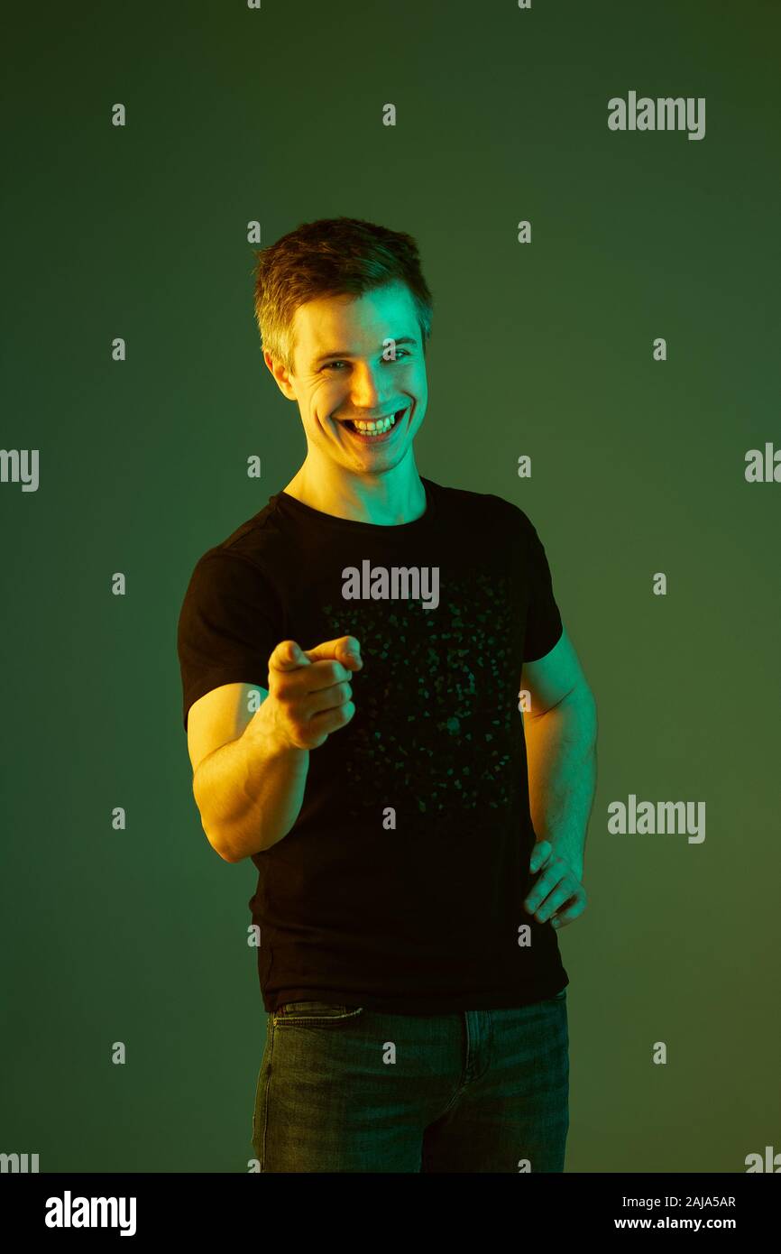 Pointing, choosing you. Caucasian man's portrait isolated on green ...