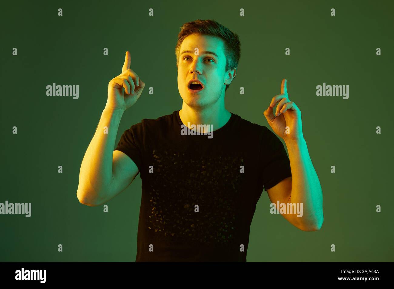 Thoughtful pointing up. Caucasian man's portrait isolated on green ...