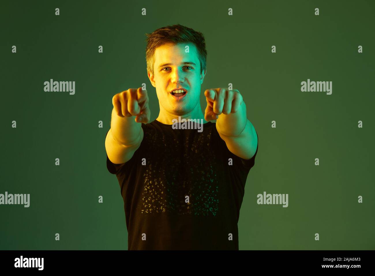 Pointing, choosing you. Caucasian man's portrait isolated on green ...