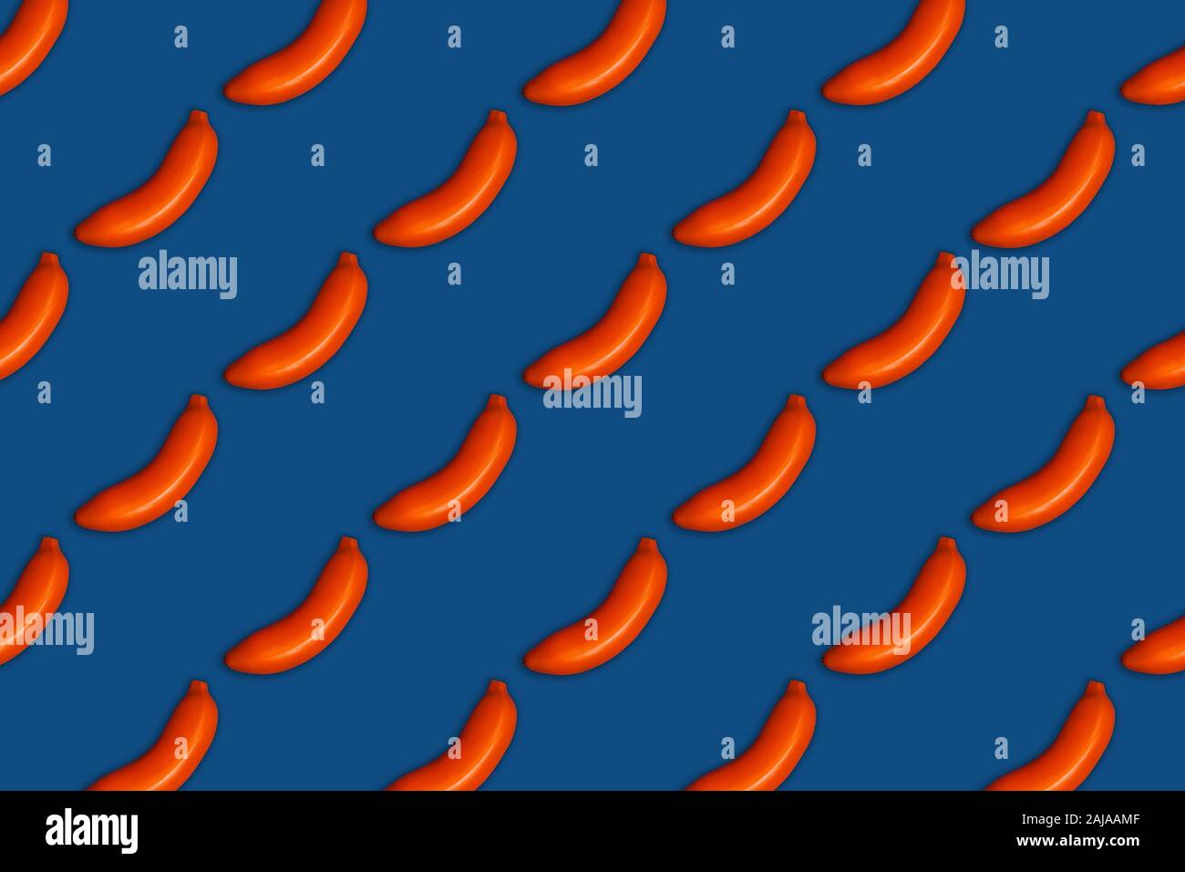Classic blue food pattern of painted orange bananas. Flat lay, top view ...