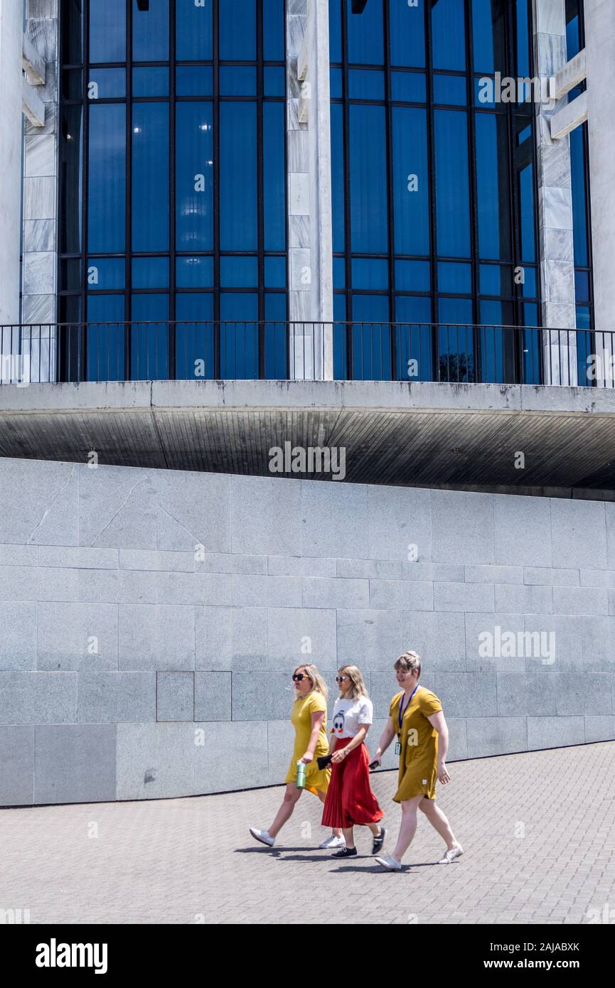 A group of three women walking in front of "The Beehive" government ...
