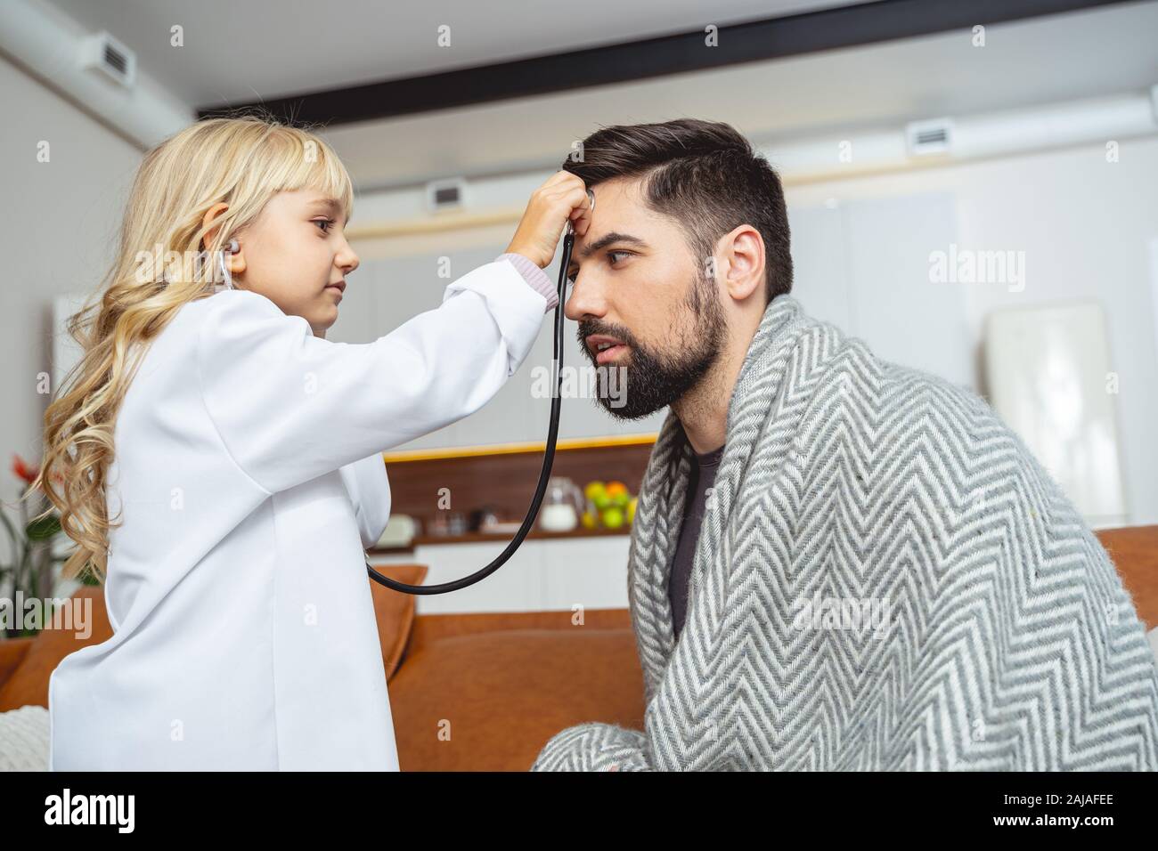 Little girl pressing stethoscope to forehead of her dad Stock Photo - Alamy