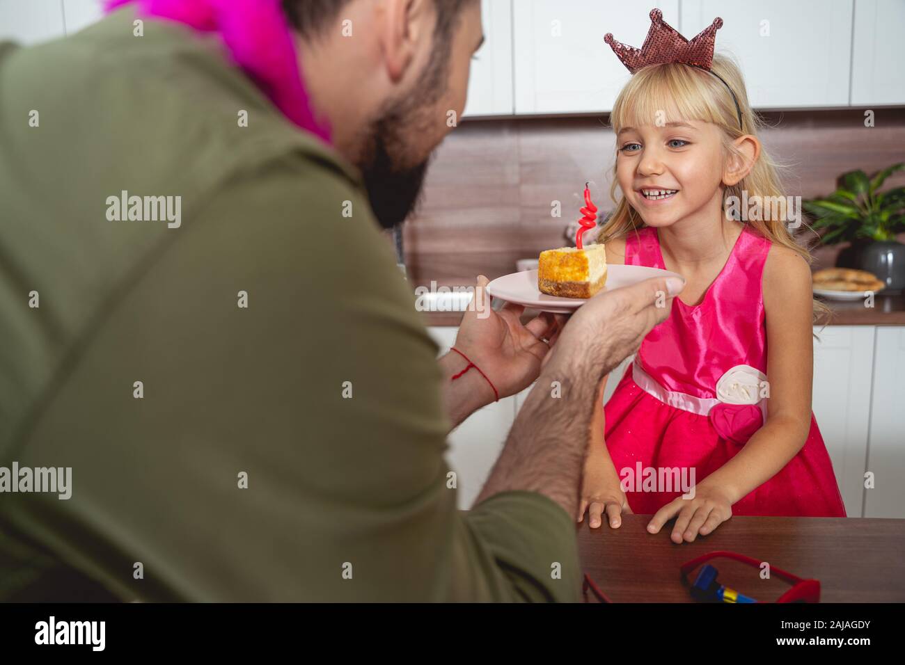 Father giving piece of cake to smiling daughter Stock Photo - Alamy