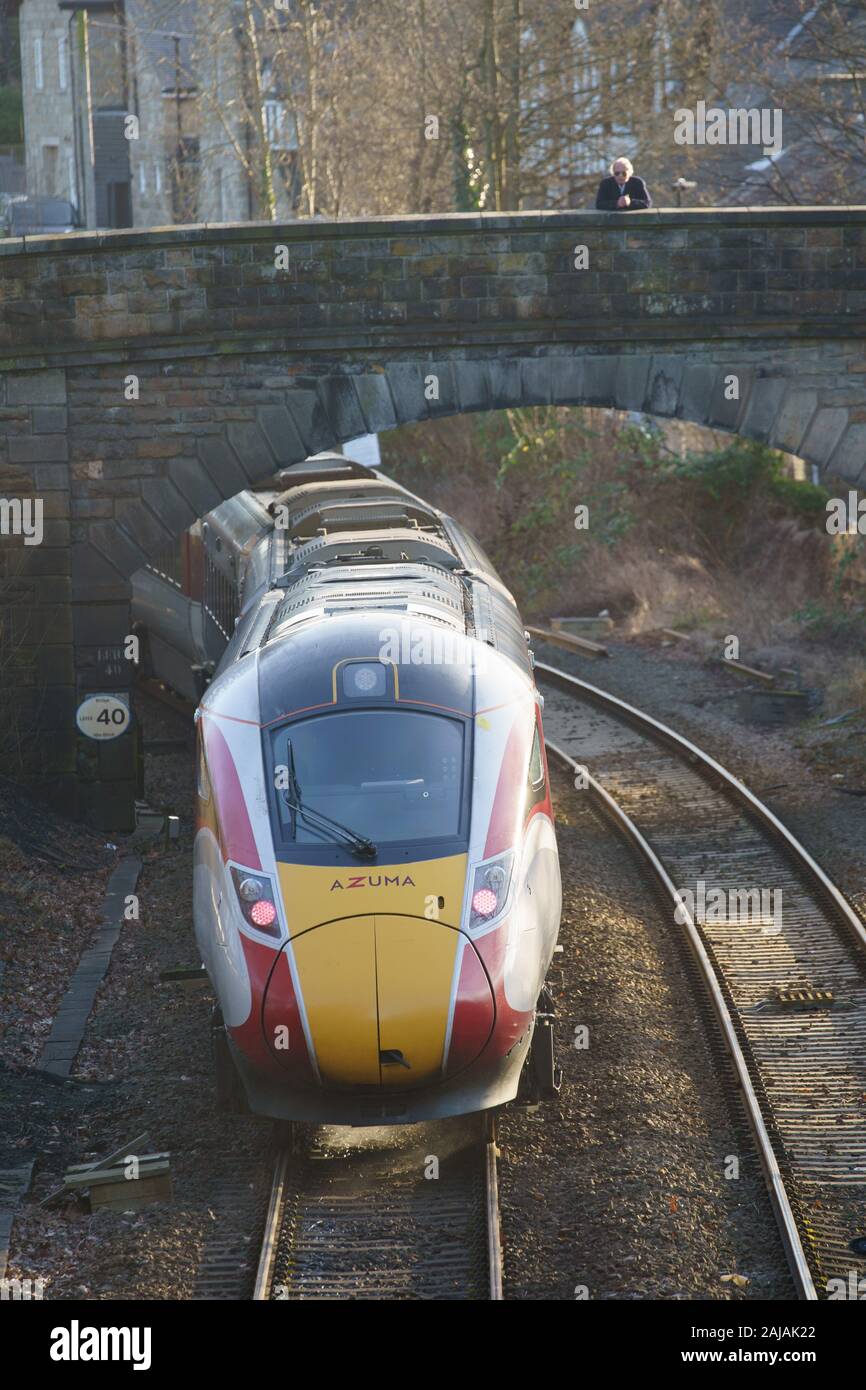 A man watching a new Azuma Train travelling underneath a bridge as it ...