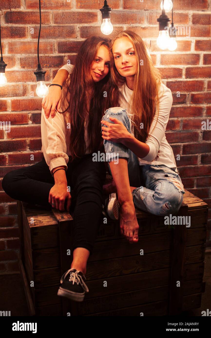 two teenage girl friends together having fun in modern loft interior ...