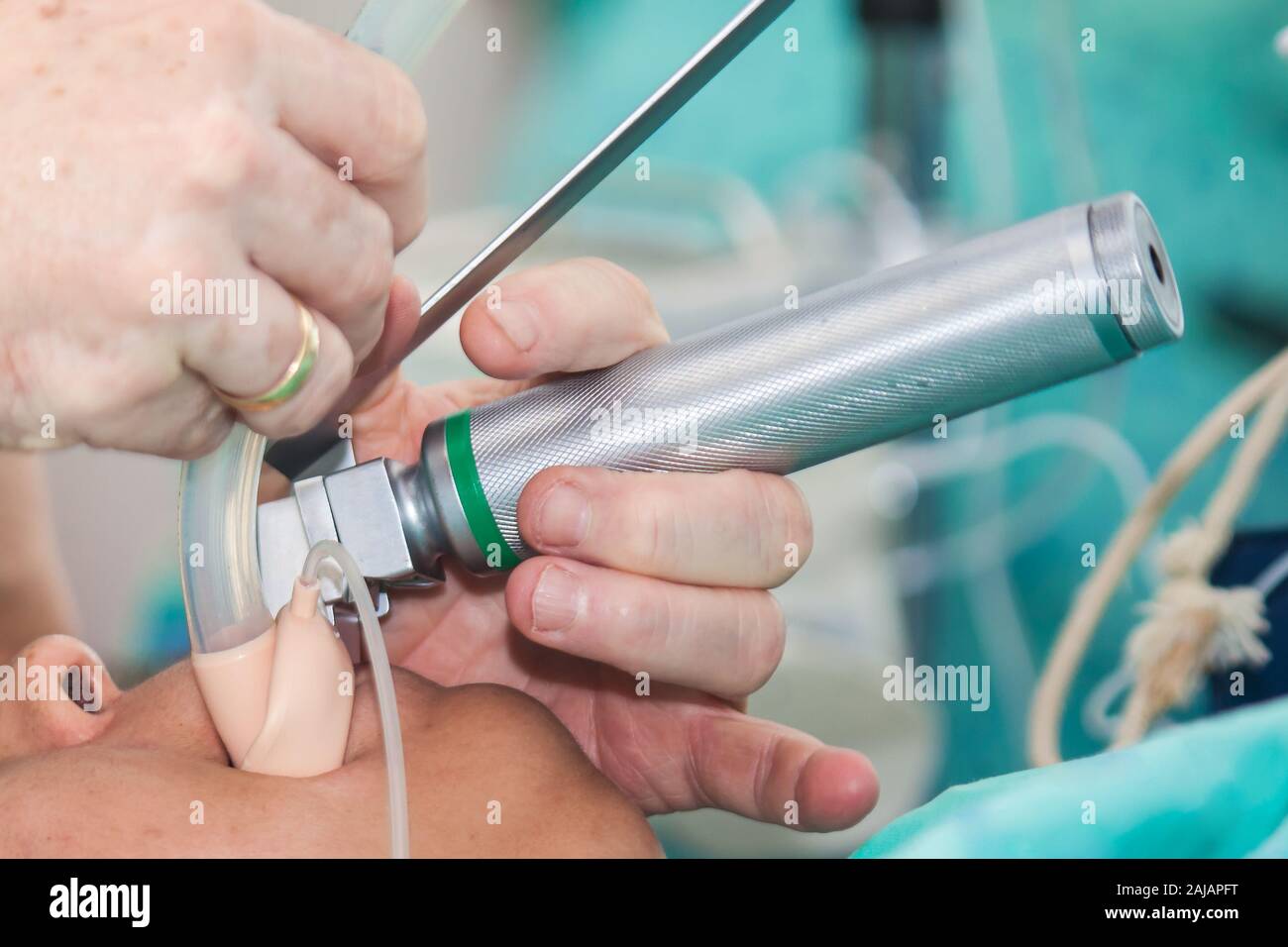 Anesthesiologist performing an endotracheal intubation to a female ...