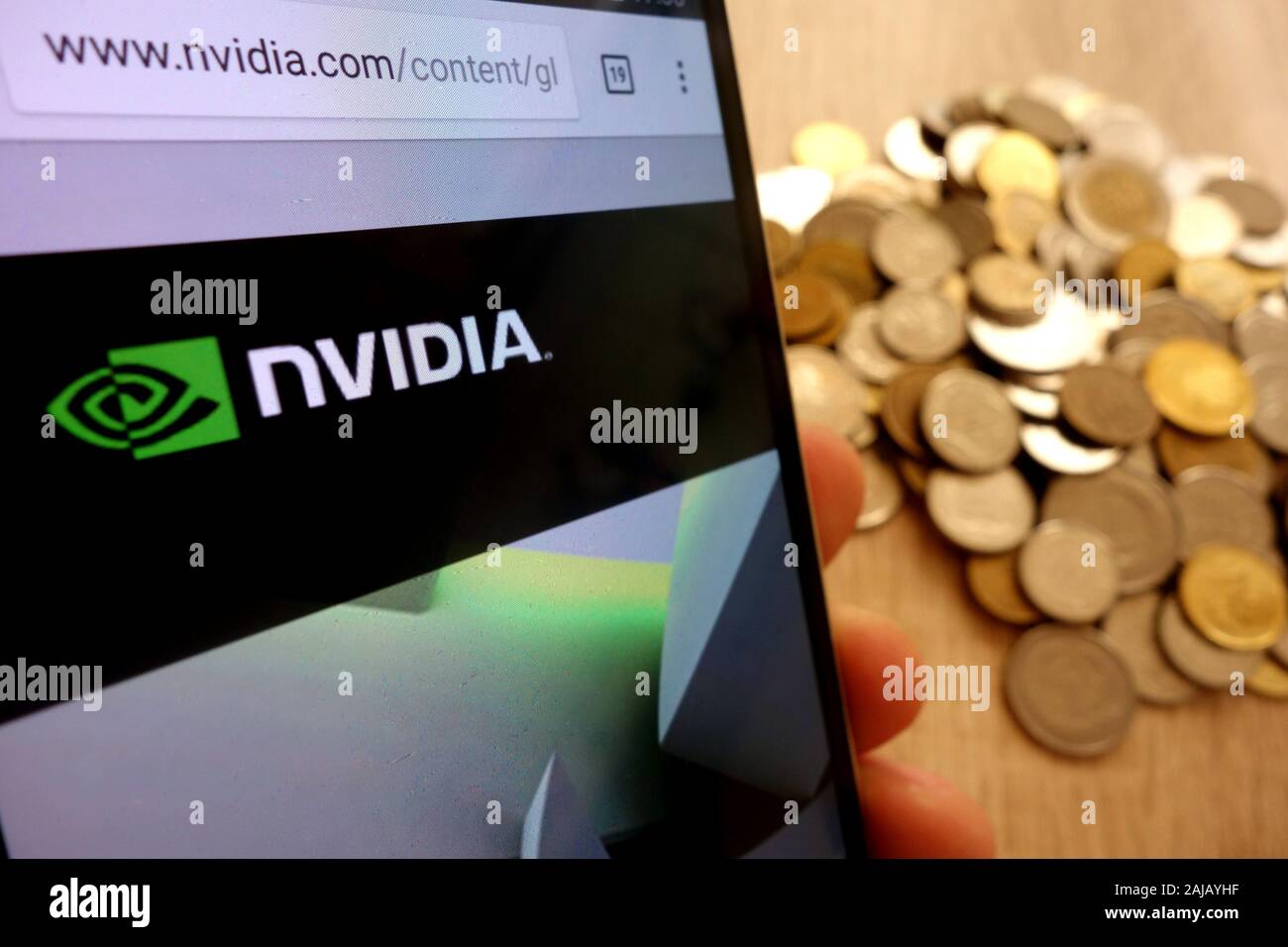 Nvidia website displayed on smartphone and stack of coins Stock Photo ...