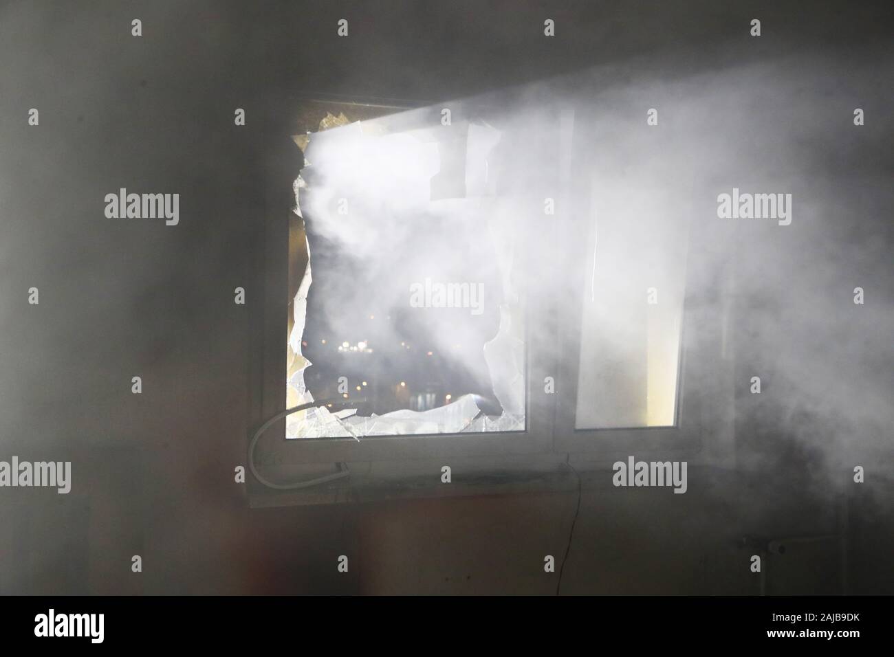 Gera, Germany. 02nd Jan, 2020. A burst window in a smoky apartment ...