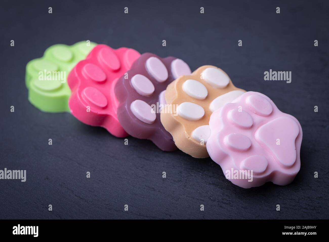 Cute colored paw shape soap on dark dark background Stock Photo - Alamy