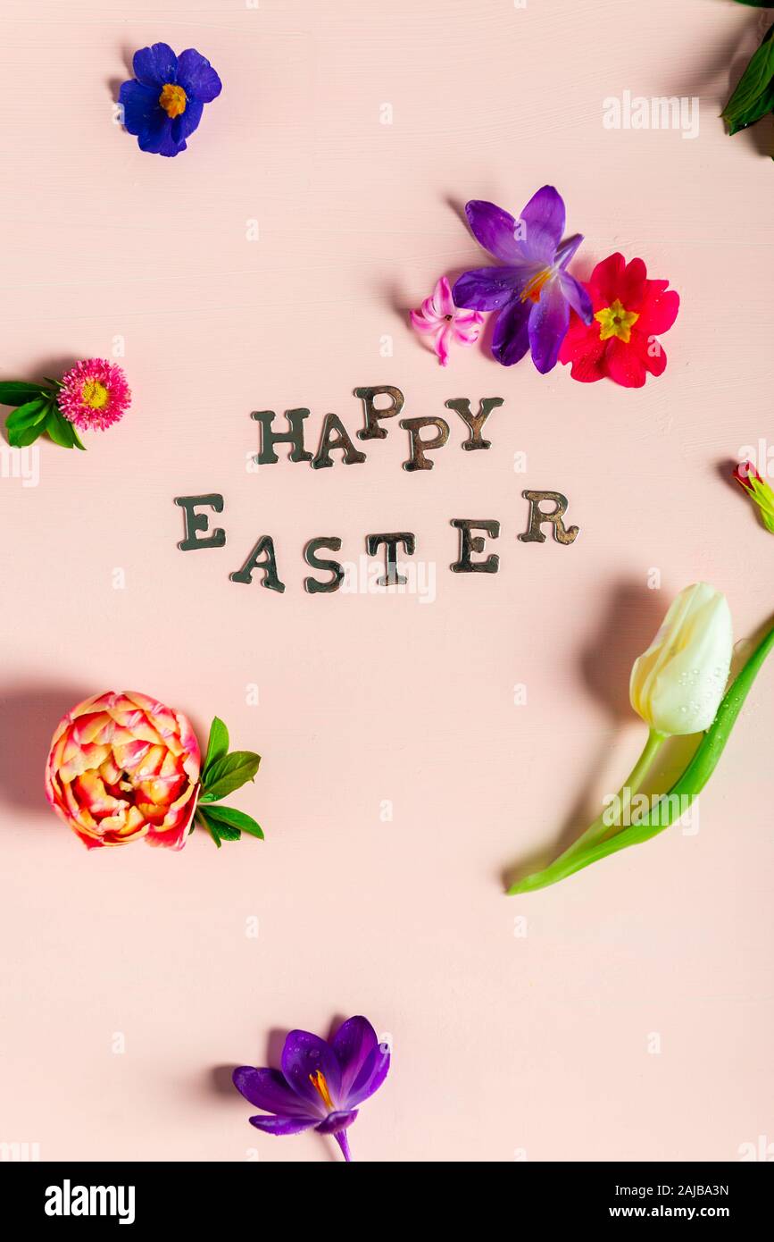 Happy Easter letters with different spring flowers around them, flat ...