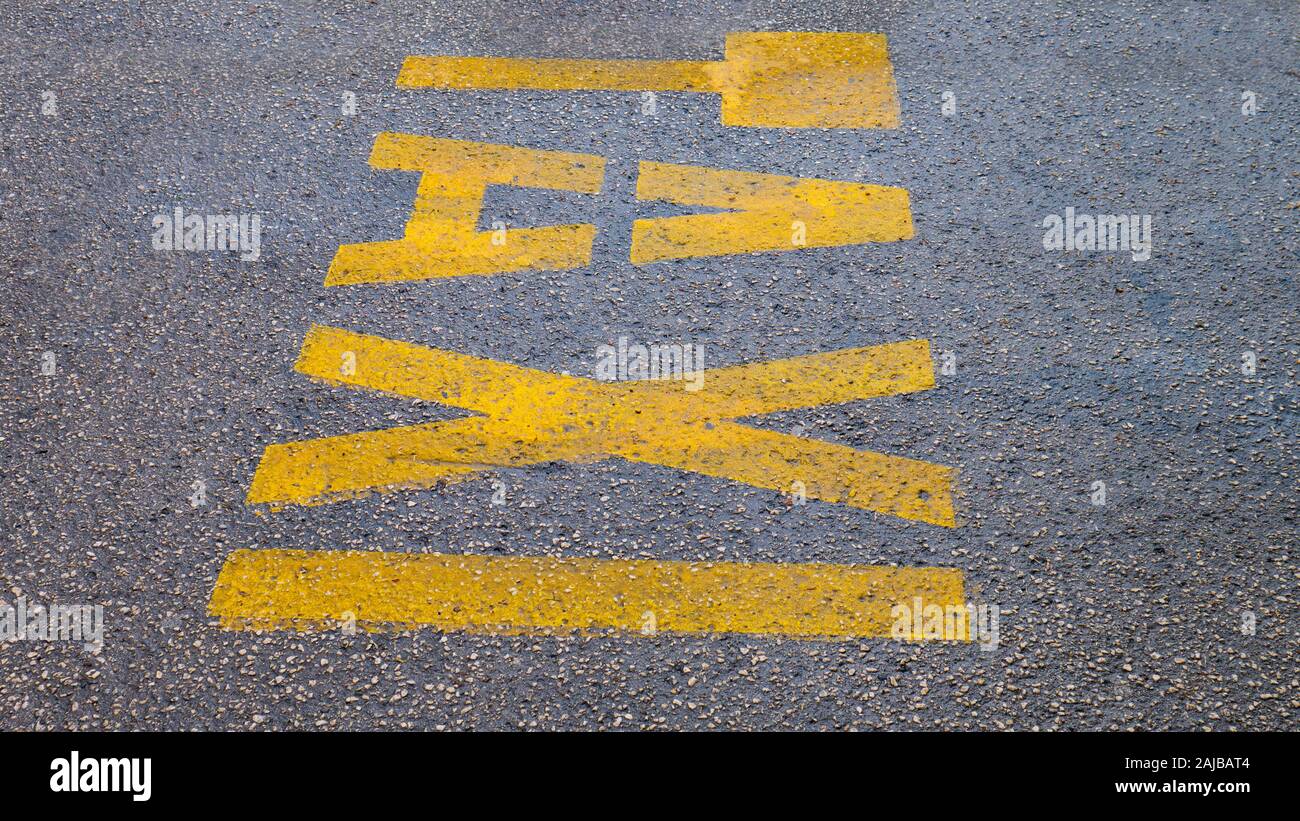 The yellow word TAXI on the pavement. Taxi marked on the floor of a ...