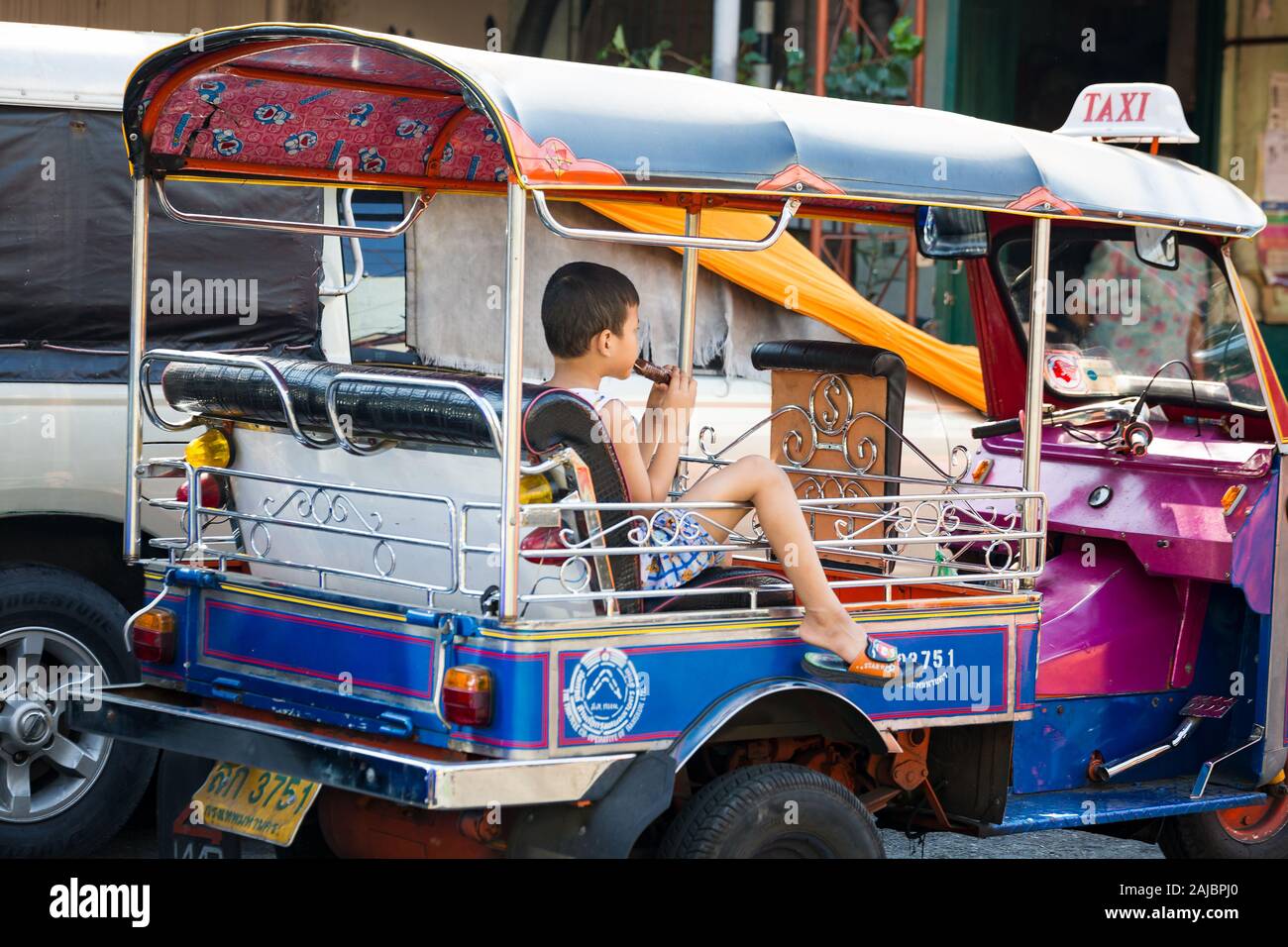 Bangkok, Thailand - December 09 2017: A boy sitting in a taxi Tuk-Tuk ...