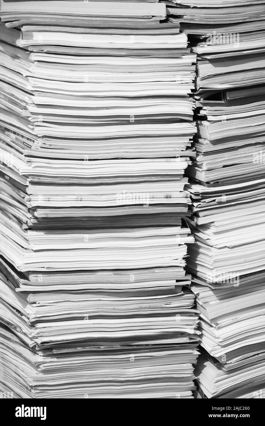 A close-up black-and-white image of a tall pile of papers, documents ...