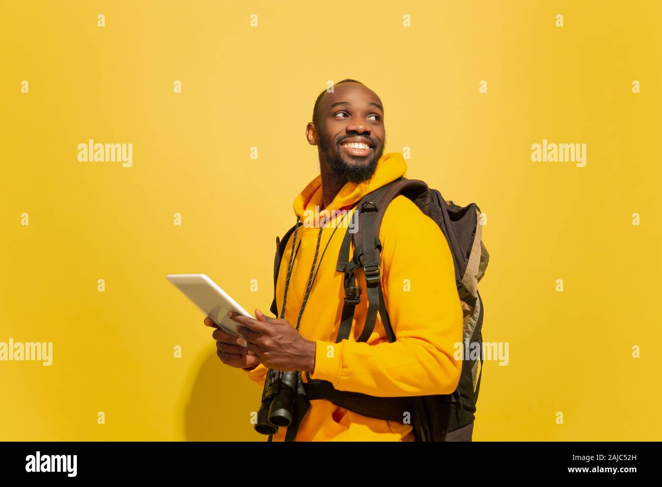 Using tablet, travel vlogging. Portrait of a cheerful young african ...