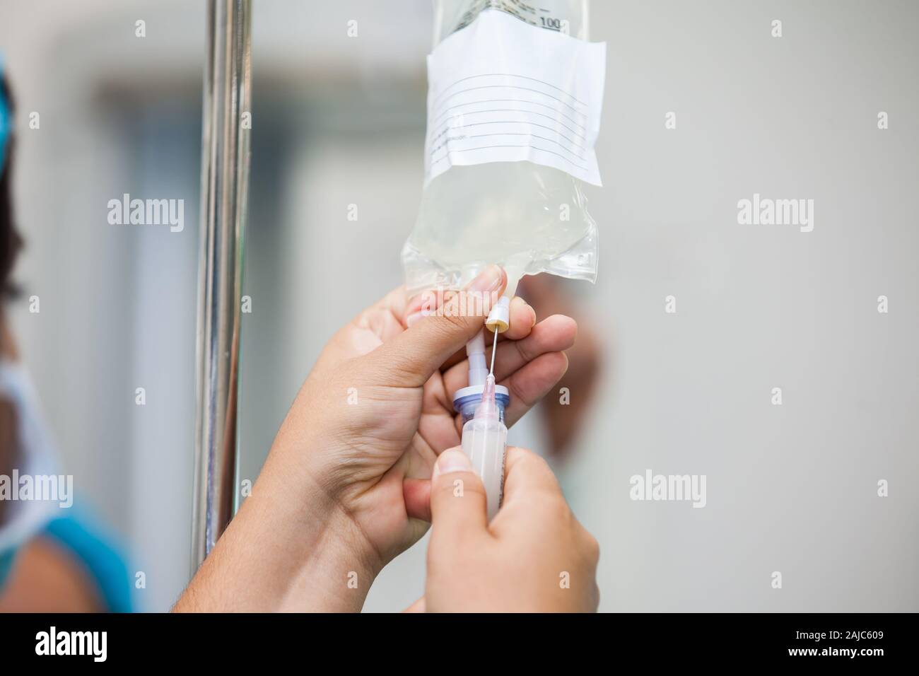 Nurse injecting a drug through an infusion system Stock Photo - Alamy