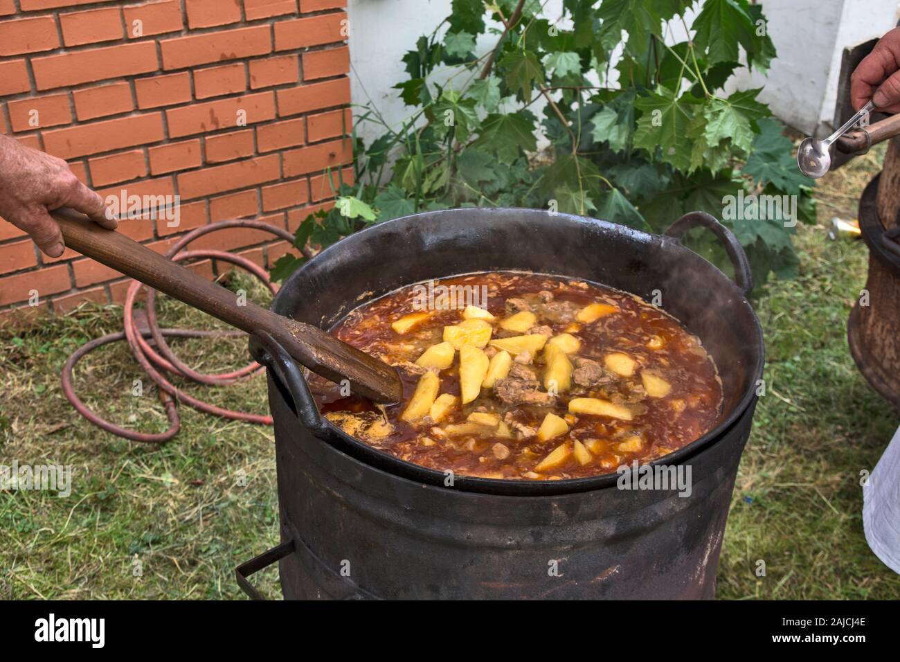Traditional stew cooking in a large metal outdoor cauldron Stock Photo ...