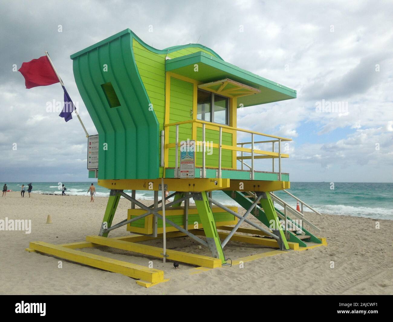 Bright green and yellow lifeguard stand with a red flag Stock Photo - Alamy