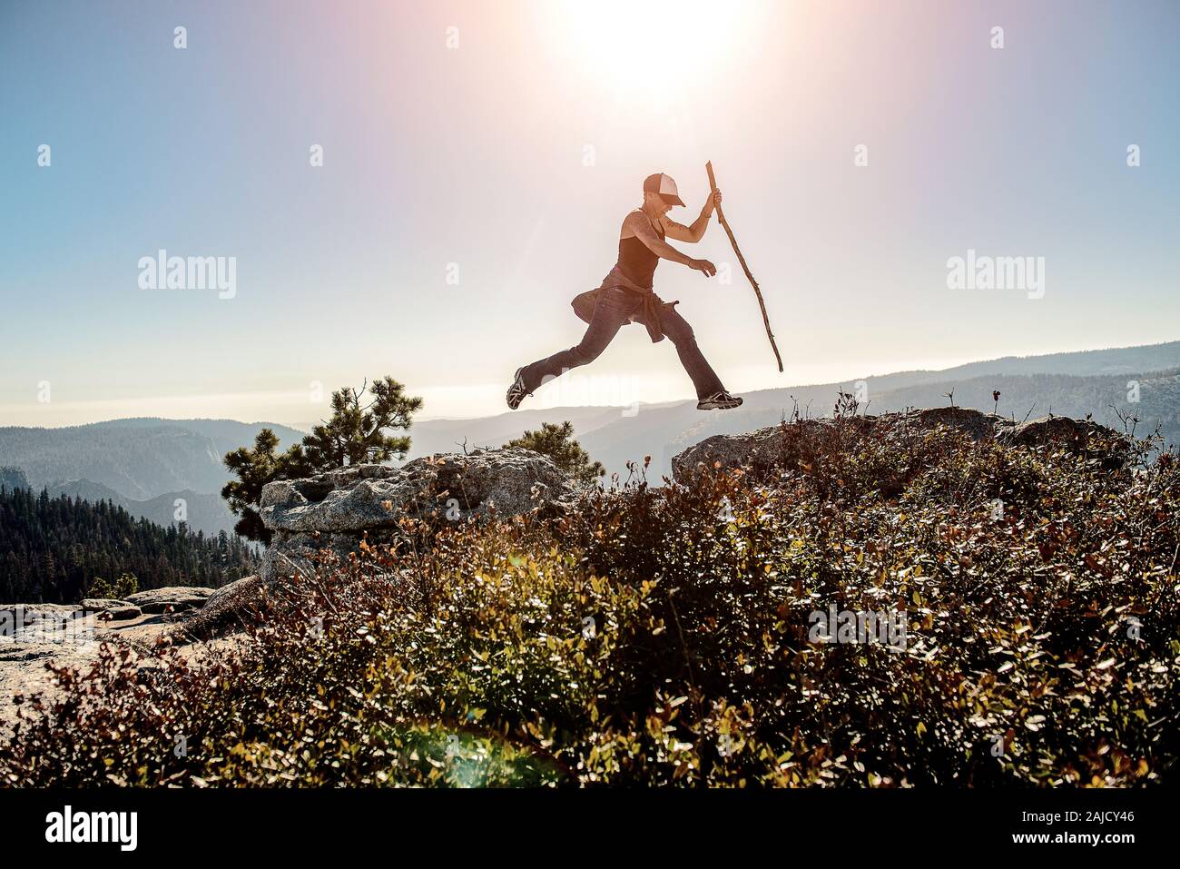 woman jumping over rocks in california Stock Photo - Alamy