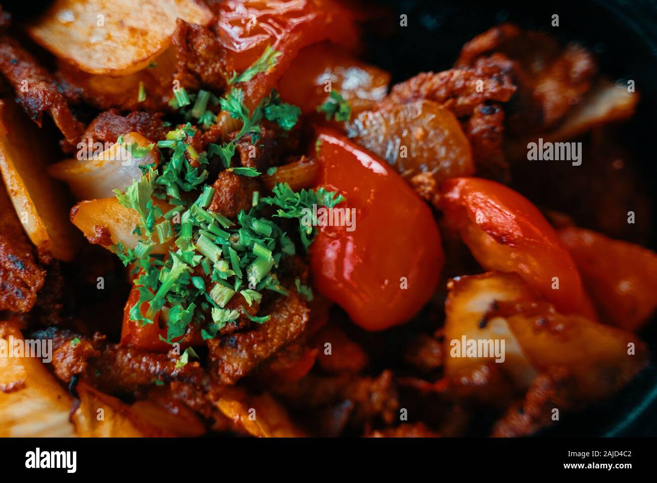 Fried food. Meat on a brazier with tomatoes and onions. View from above ...
