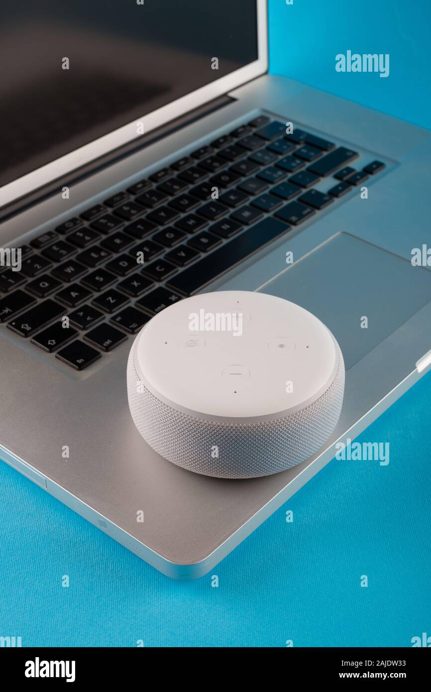 white digital voice assistant with computer on light blue background ...