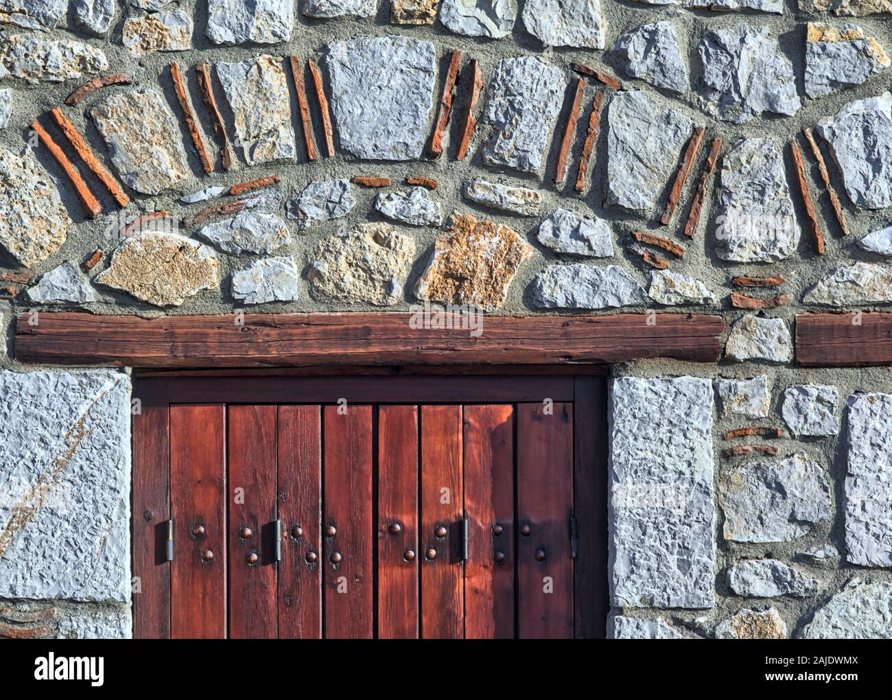 Stone wall with wooden closed shutters close up. Traditional ...