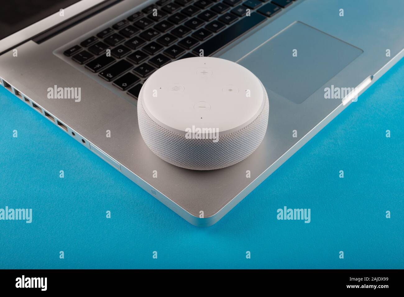 white digital voice assistant with computer on light blue background ...