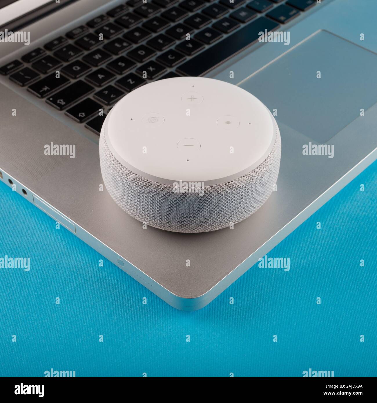 white digital voice assistant with computer on light blue background ...