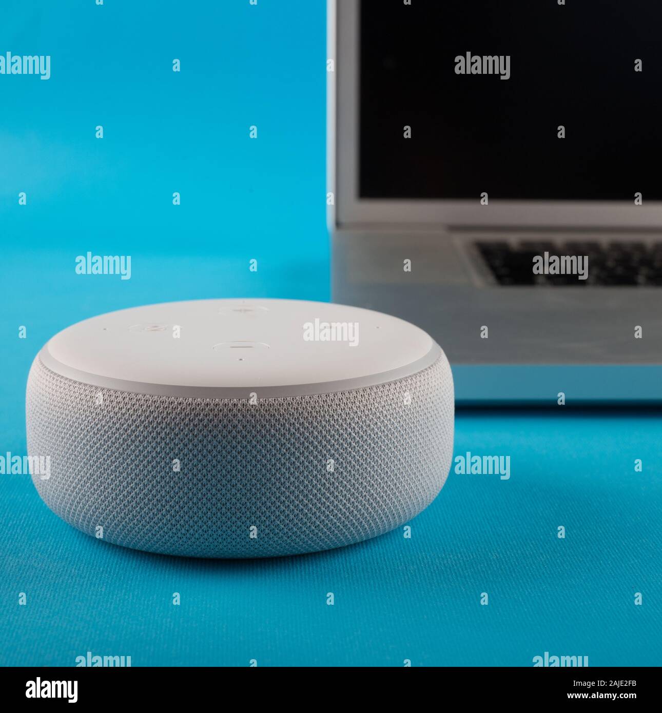 white digital voice assistant with computer on light blue background ...