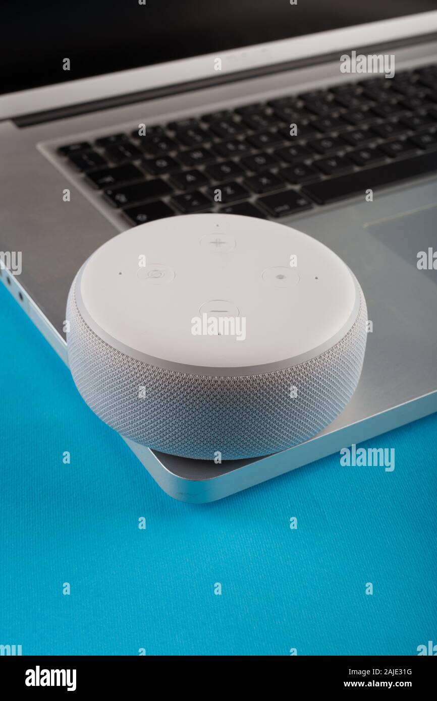white digital voice assistant with computer on light blue background ...