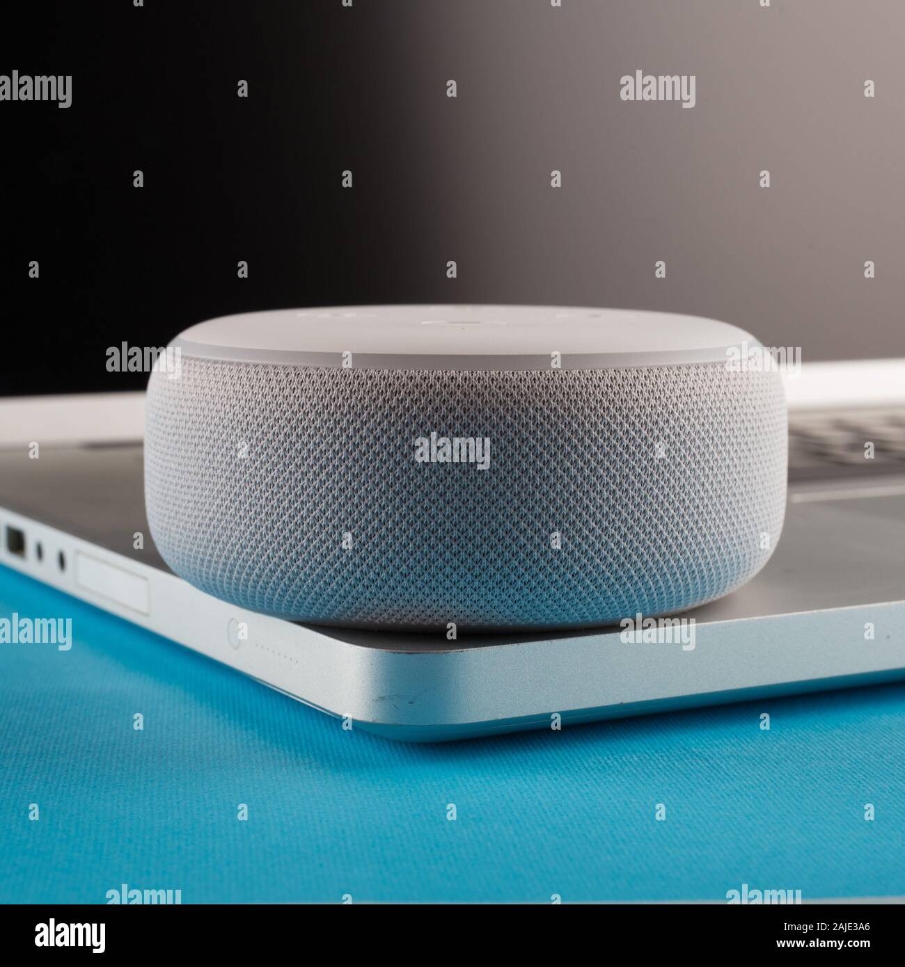 white digital voice assistant with computer on light blue background ...