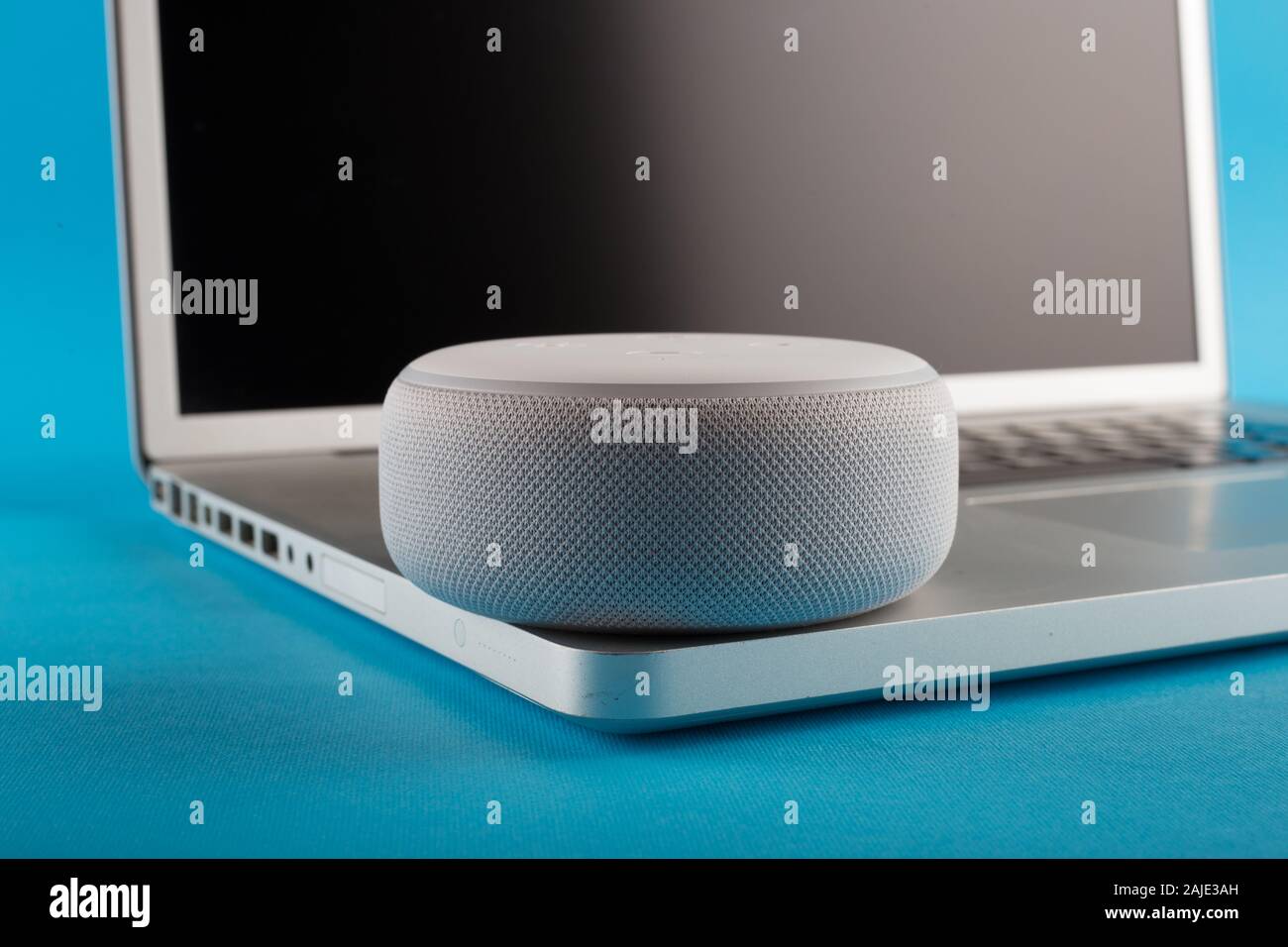 white digital voice assistant with computer on light blue background ...