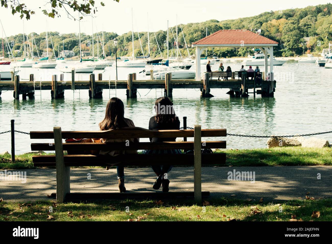 Two women chat on a park bench Stock Photo - Alamy
