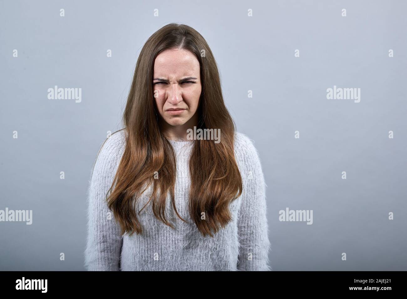 Disappointed lady crying, squeezing face wearing fashion blue sweater ...