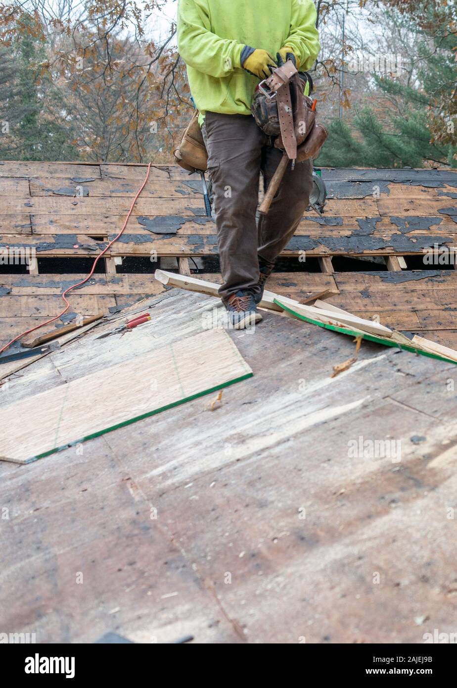 Roofer replaces rotted wood with new on the roof of an old house Stock ...