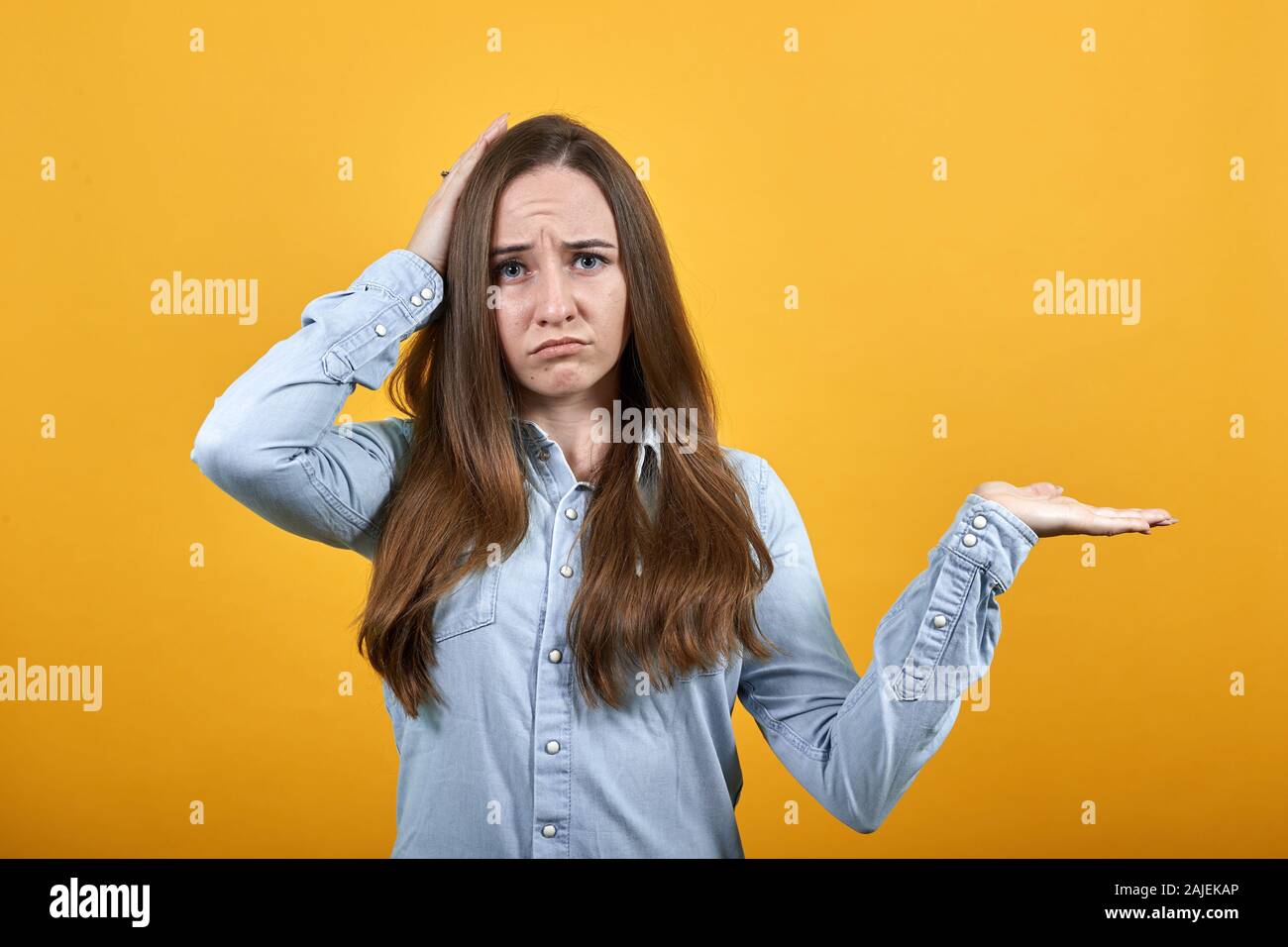 Disappointed attractive woman keeping hand on head, spread hand Stock ...