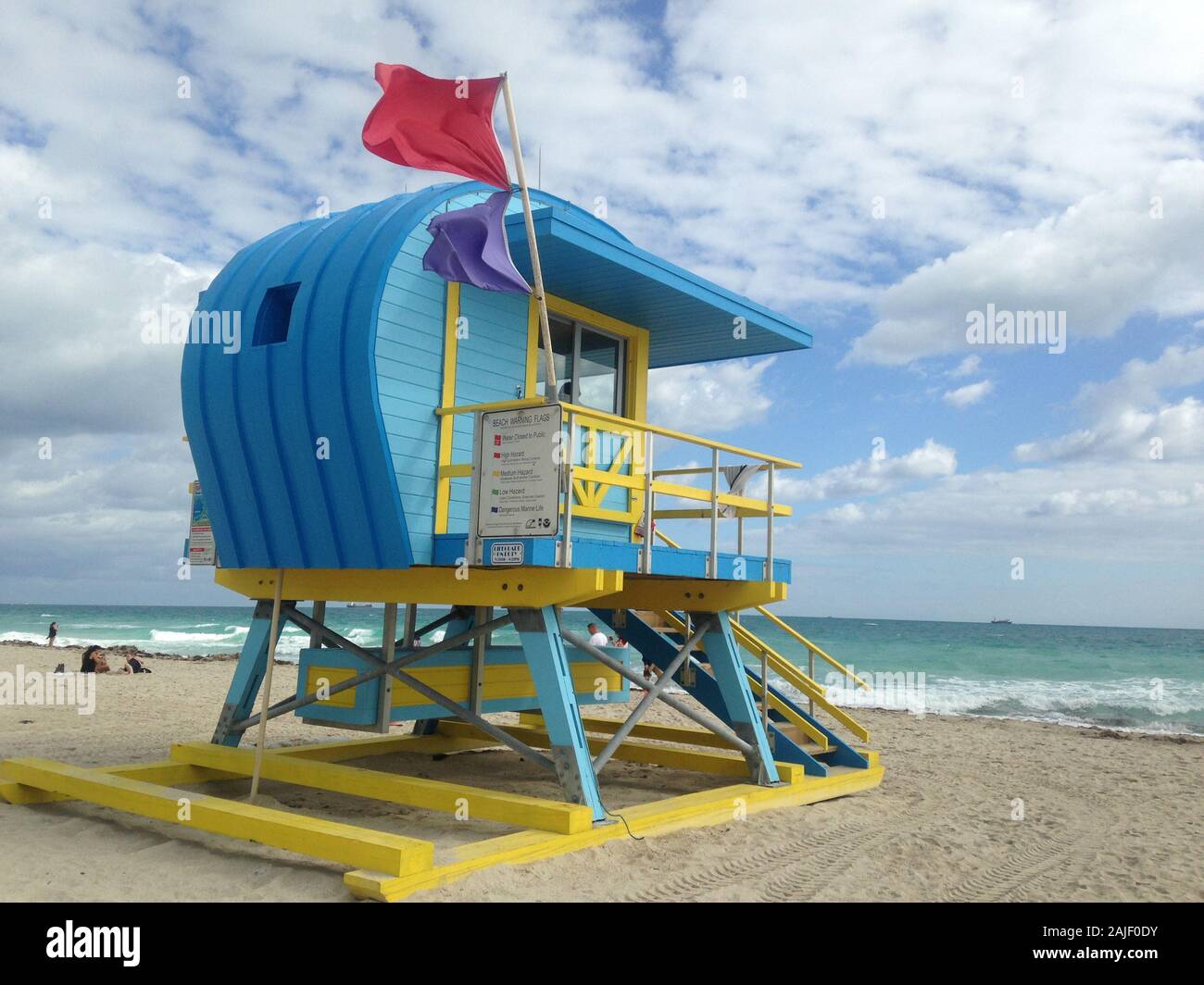 Blue and yellow lifeguard hut with red flag on the beach Stock Photo ...