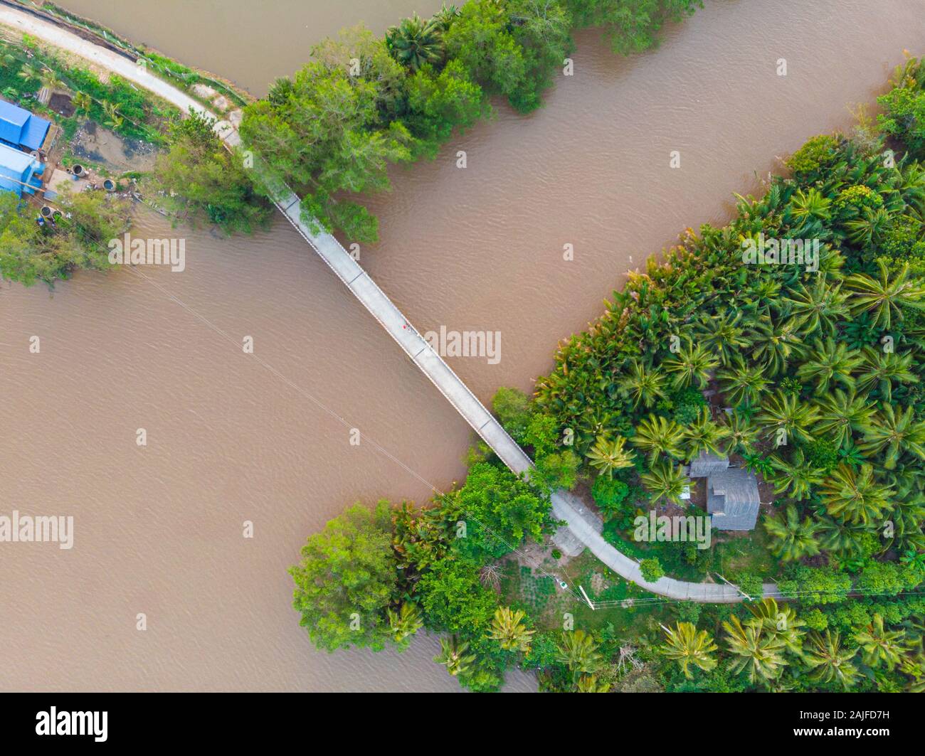 Aerial top down view bridge over muddy water canal in the Mekong River ...