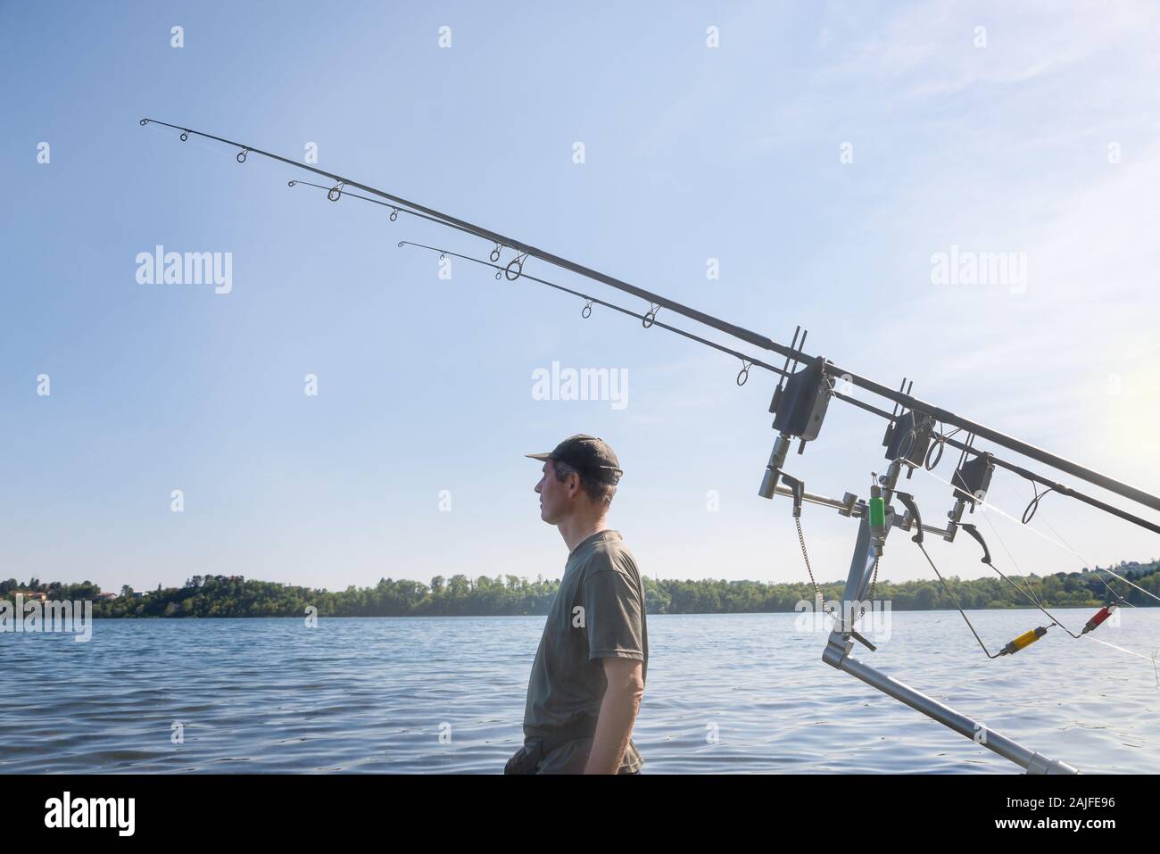 Fishing adventures, carp fishing. Man fishing on the lake using modern ...