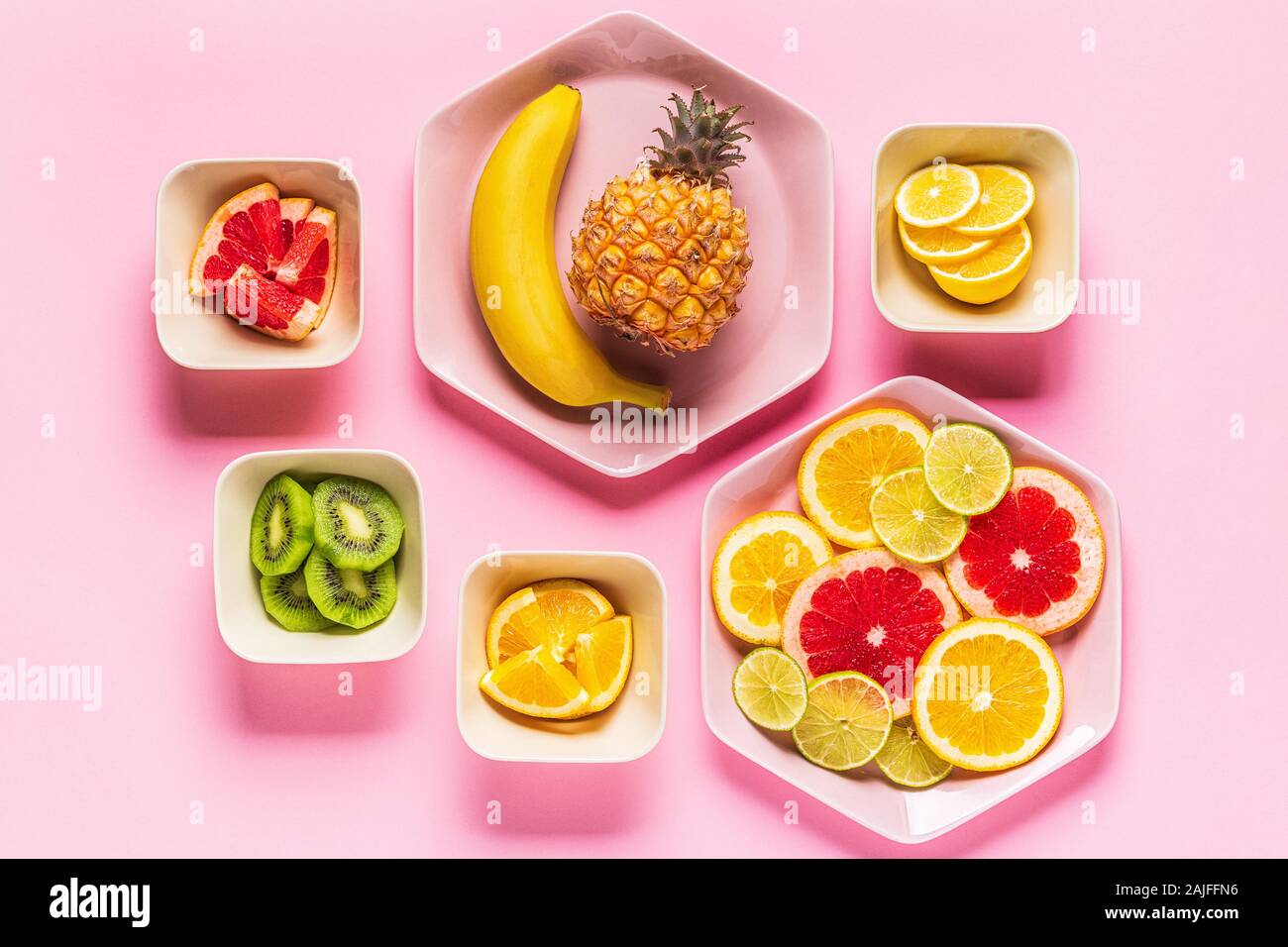 Tropical fruits whole and slices on plates, top view Stock Photo - Alamy