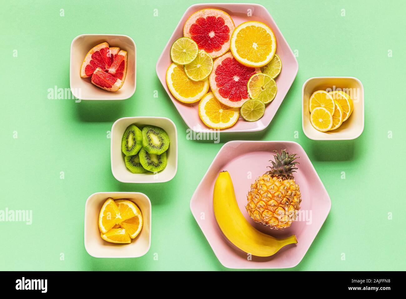 Tropical fruits whole and slices on plates, top view Stock Photo - Alamy