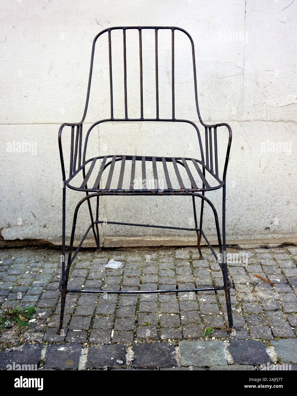 Single metal chair on the street. Grey colors only Stock Photo - Alamy