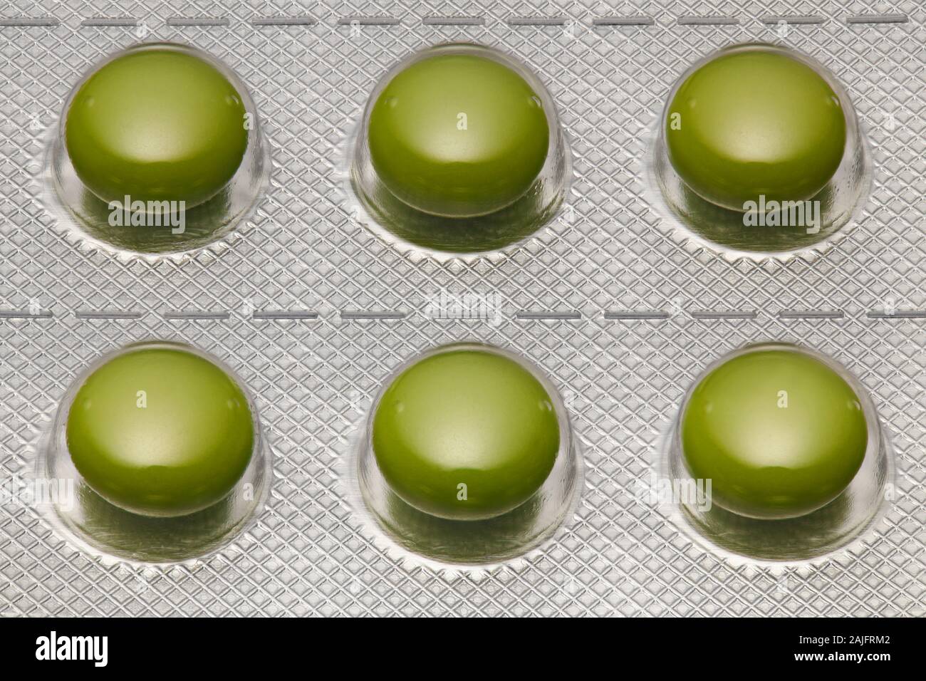 Green tablets in blister pack arranged with beautiful pattern. Global ...