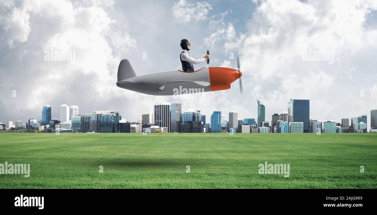 Businessman in aviator hat and goggles driving propeller plane ...