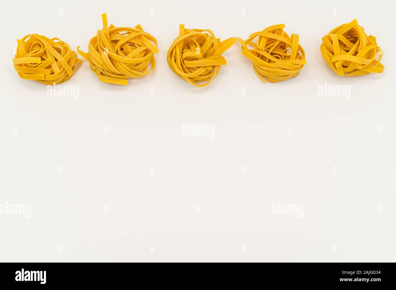 italian tagliatelle pasta nests on a white background - natural food ...