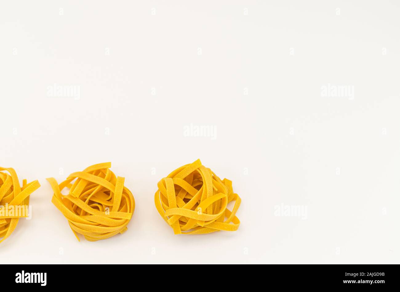 italian tagliatelle pasta nests on a white background - natural food ...